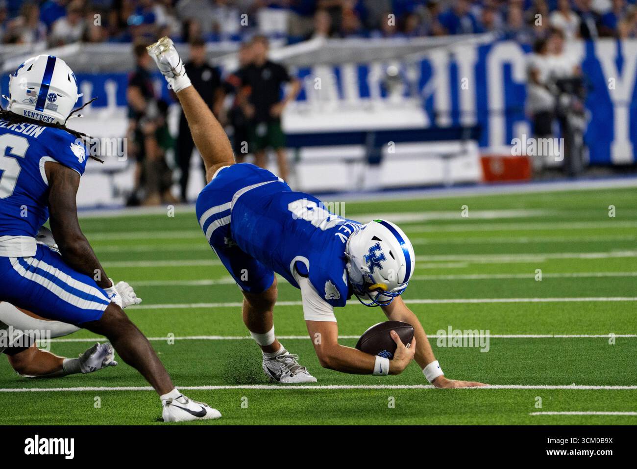 Kentucky quarterback Cutter Boley (8) is tripped while carrying the ...