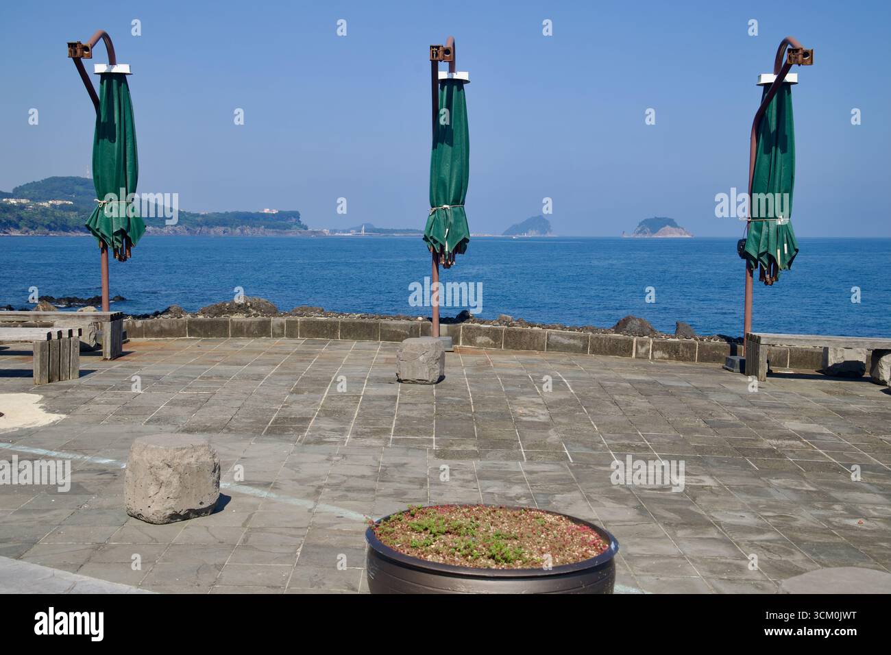A seaside terrace at Beophwan shows folded green umbrellas facing the ...