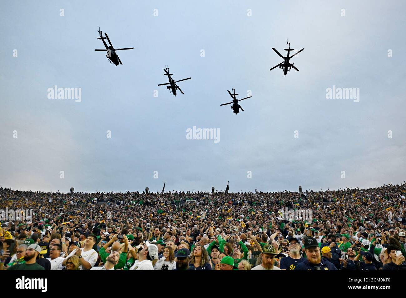 Helicopters perform a flyover before an NCAA college football game ...
