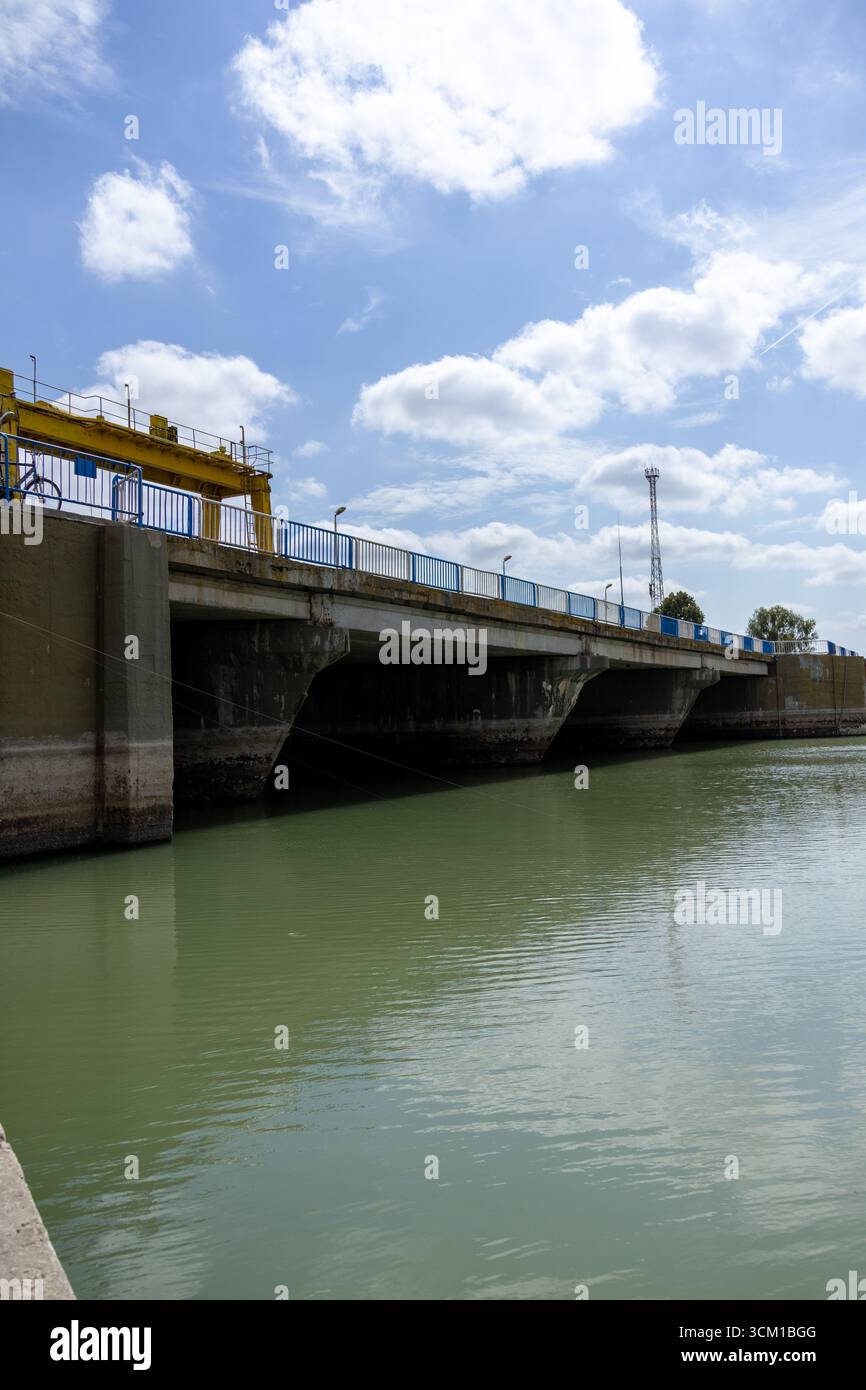 Industrial water dam and canal infrastructure with flowing river and ...