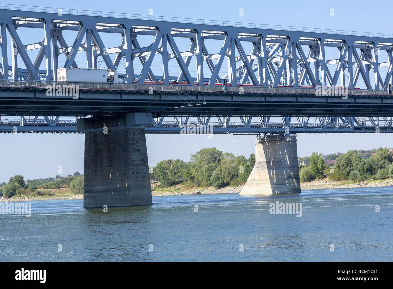 Large steel truss railway bridge crossing a wide river under a clear ...