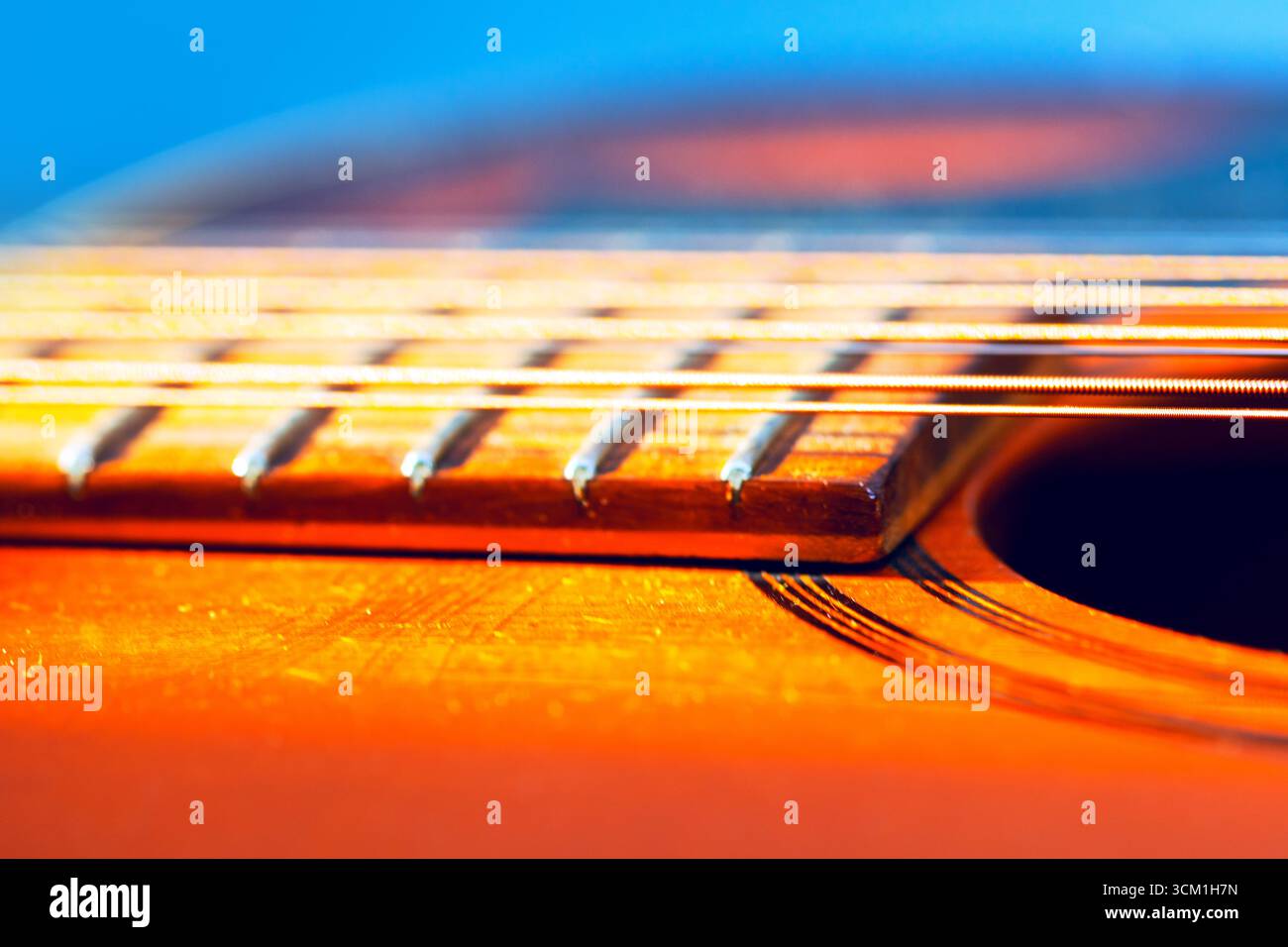 Polished surface of guitar body contrasts with frets. Low angle shot ...