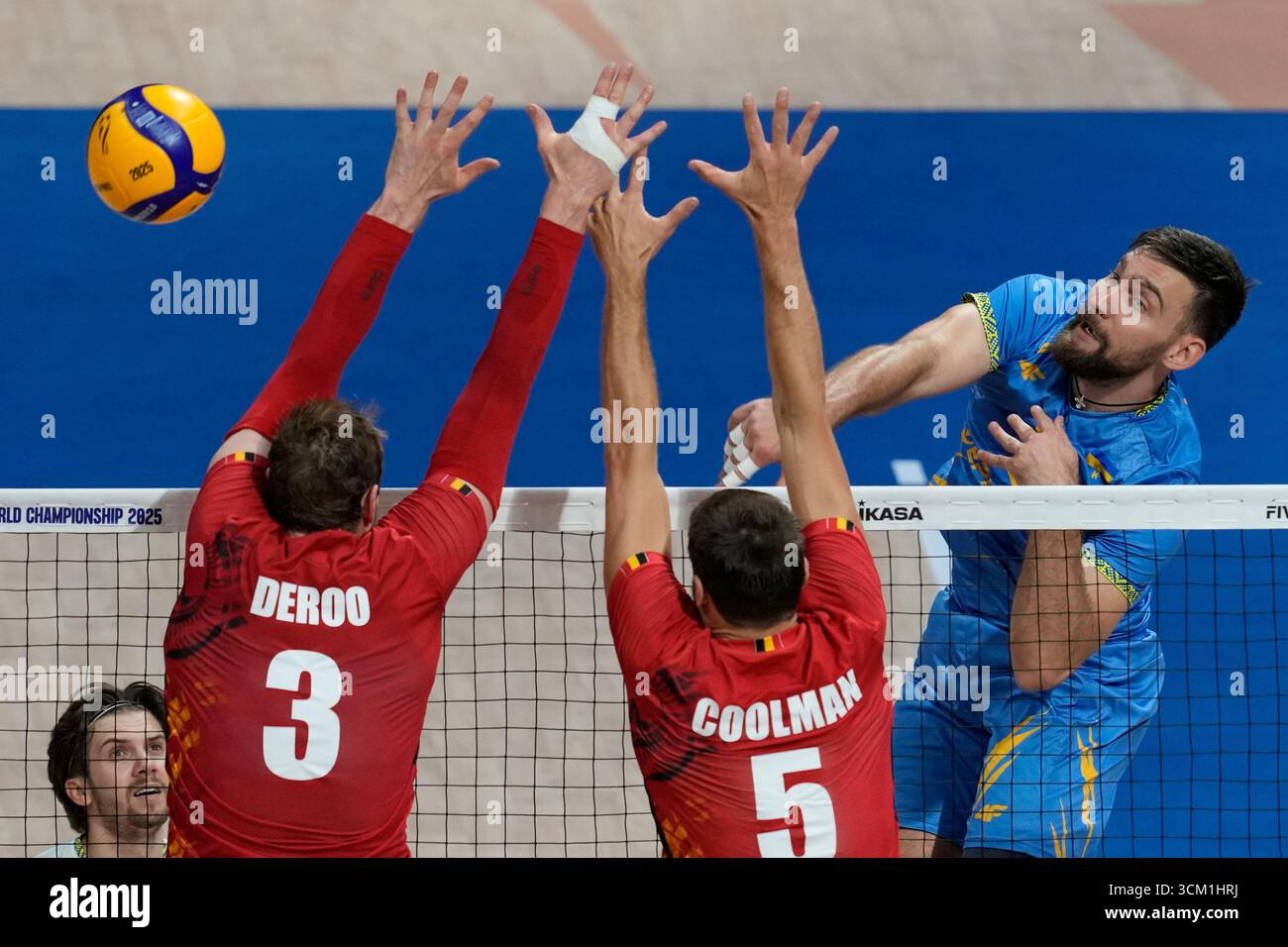 Dmytro Yanchuk, right, of Ukraine spikes the ball against Sam Deroo and ...