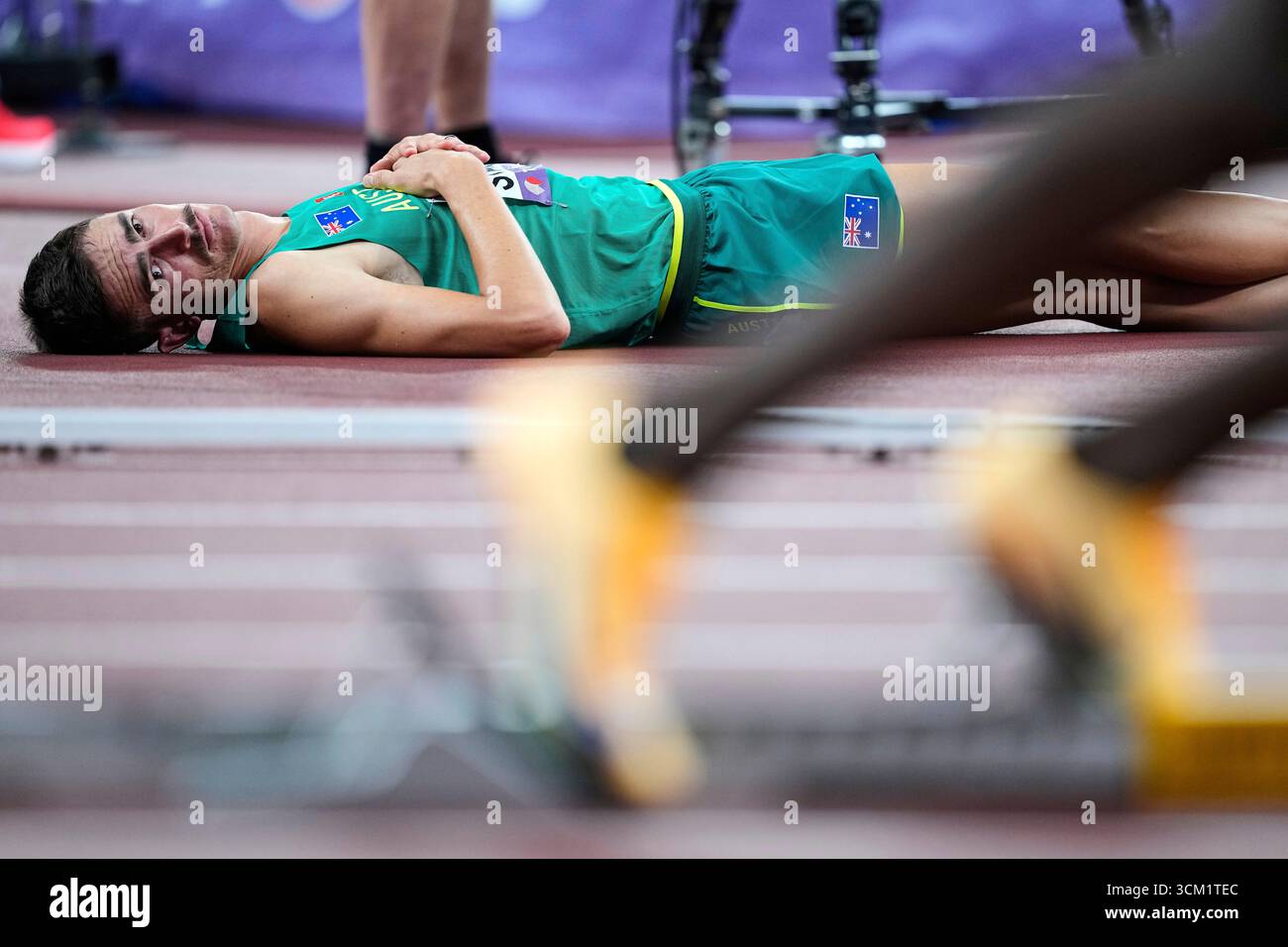 Australian high jumper Brandon Starc lays on the side of the track and ...