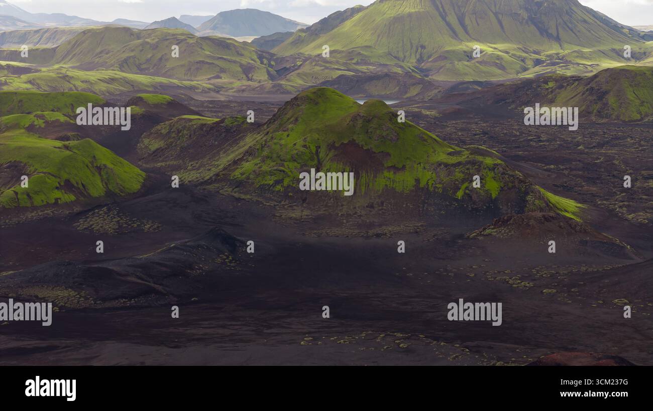 Aerial perspective of Iceland's volcanic terrain featuring dark soil ...