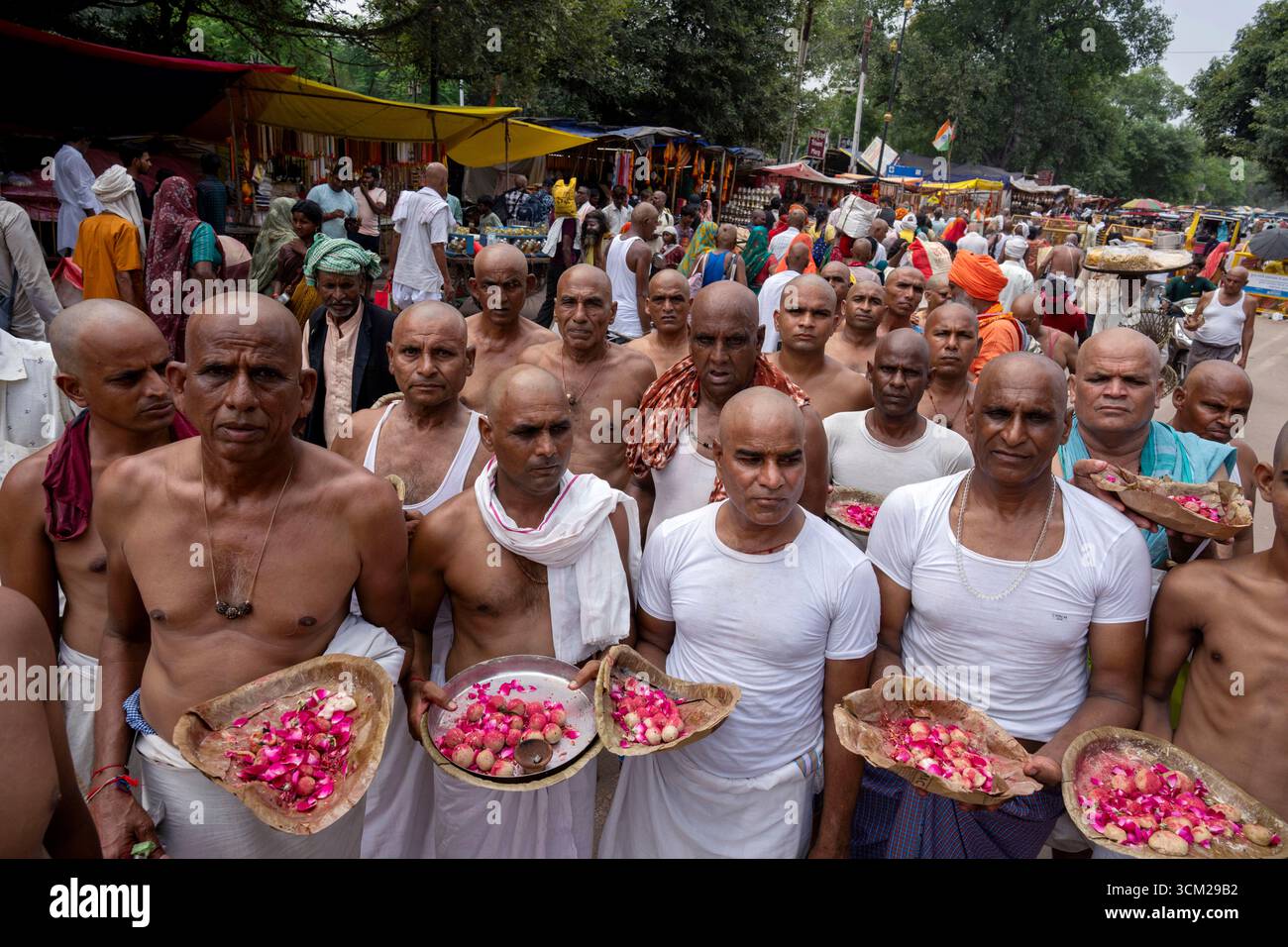 Hindu devotees walk towards the River Ganges to make their offerings ...