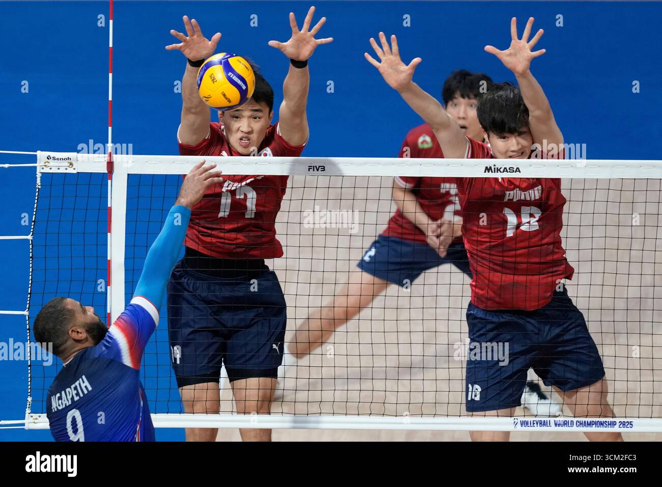 Earvin Ngapeth, left, of France hits the ball during their pool phase ...