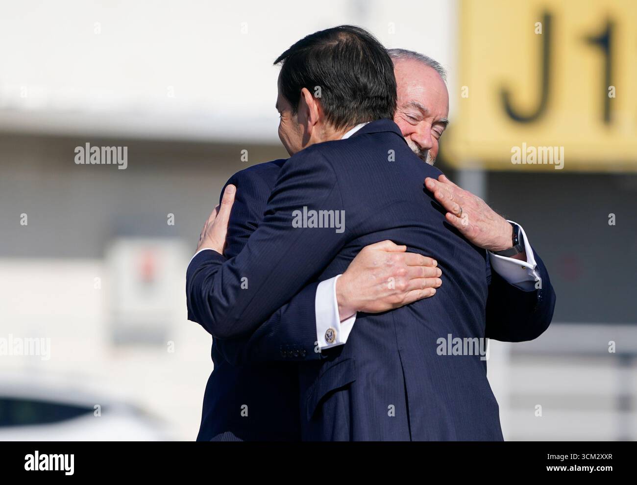 U.S. Secretary of State Marco Rubio, back to the camera, is greeted ...