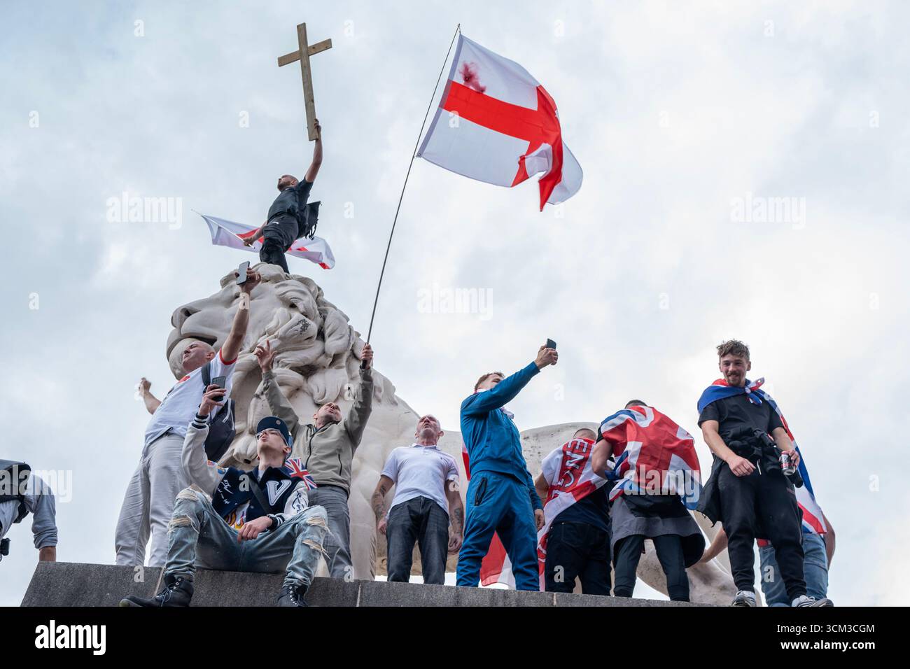 A Christian patriot on top of the lion statue on Westminster bridge ...