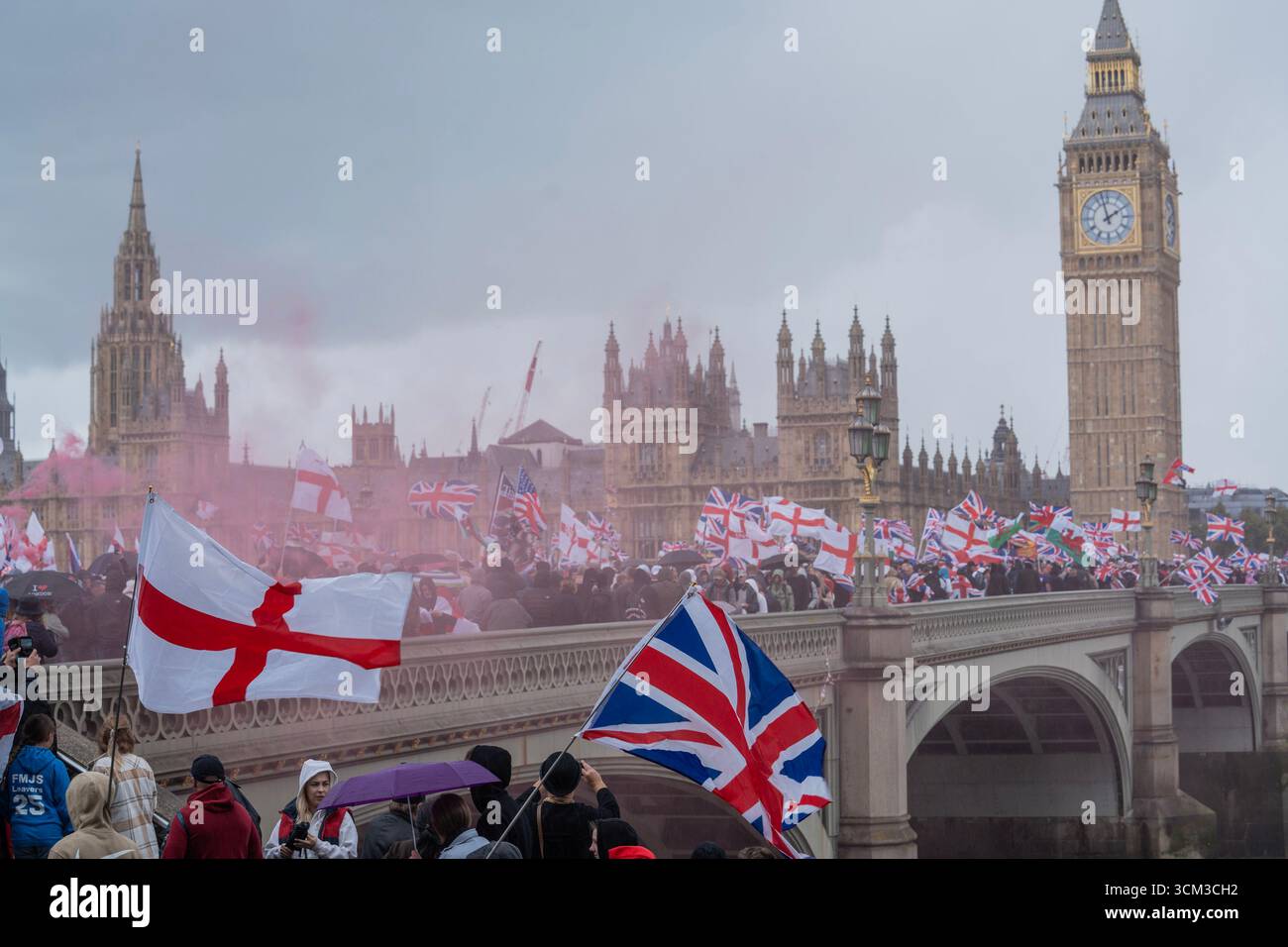 London, UK. 13th Sep, 2025. Patriots cross Westminster bridge holding ...