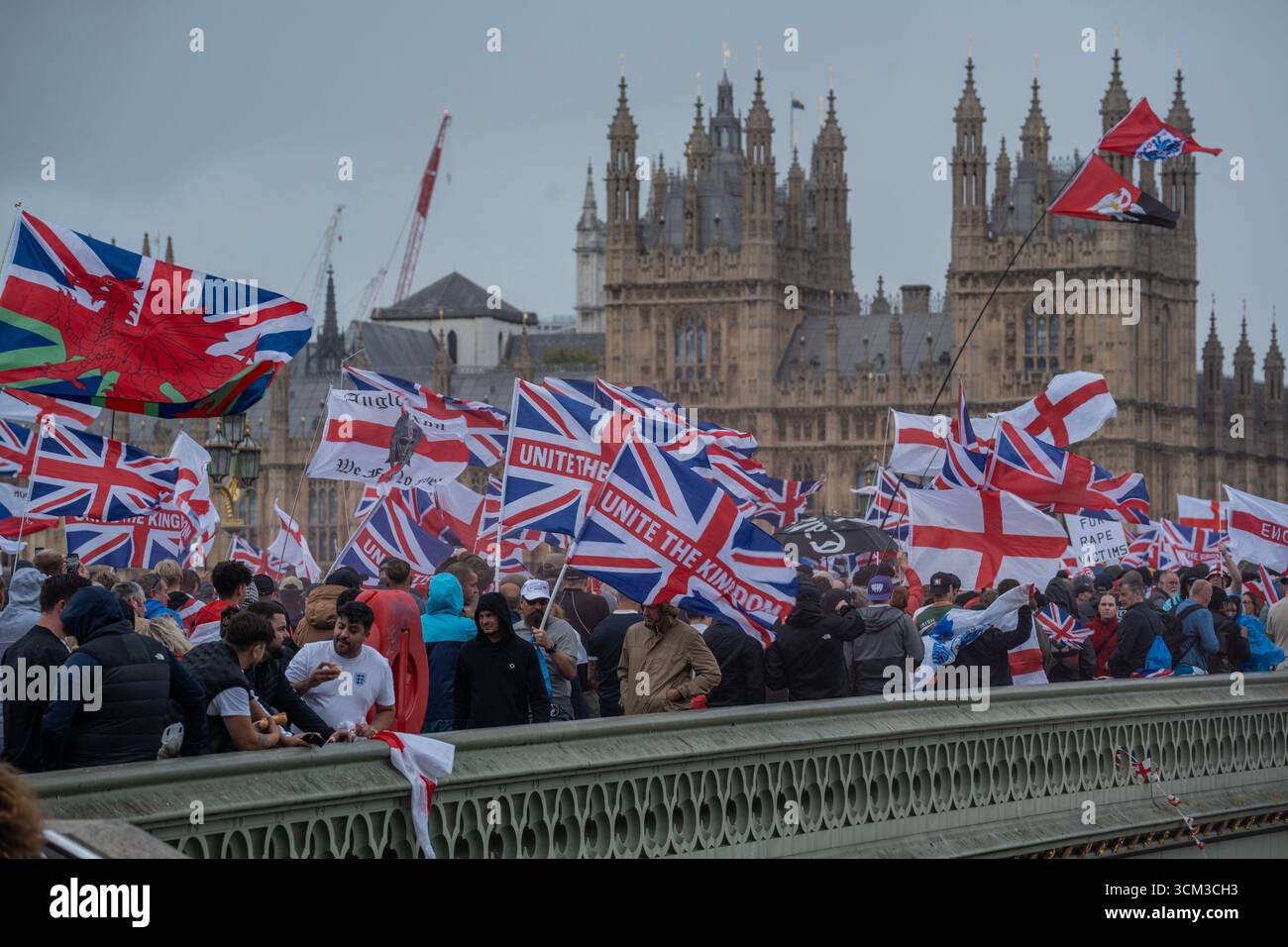 Patriots cross Westminster bridge holding aloft Union Jack flags during ...