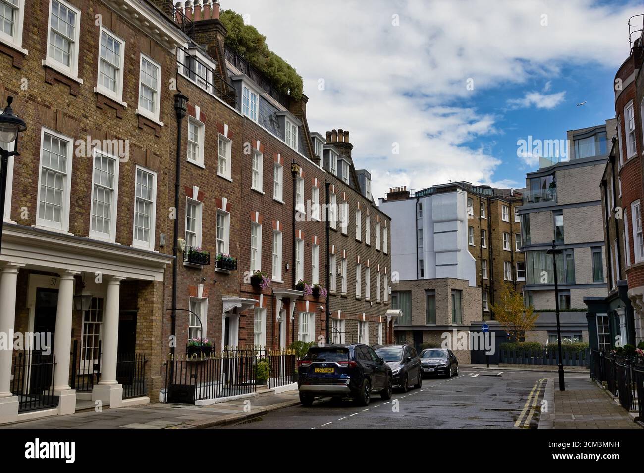 A street scene shows a row of traditional brick buildings with large ...