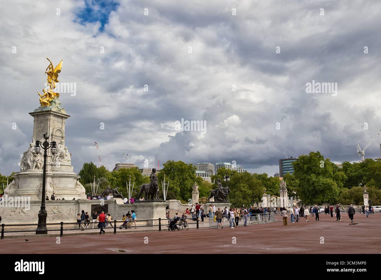 A grand golden statue atop a marble monument dominates the left, with a ...