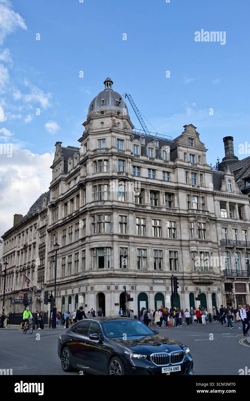 A street scene in London features a grand, ornate building with a dome ...