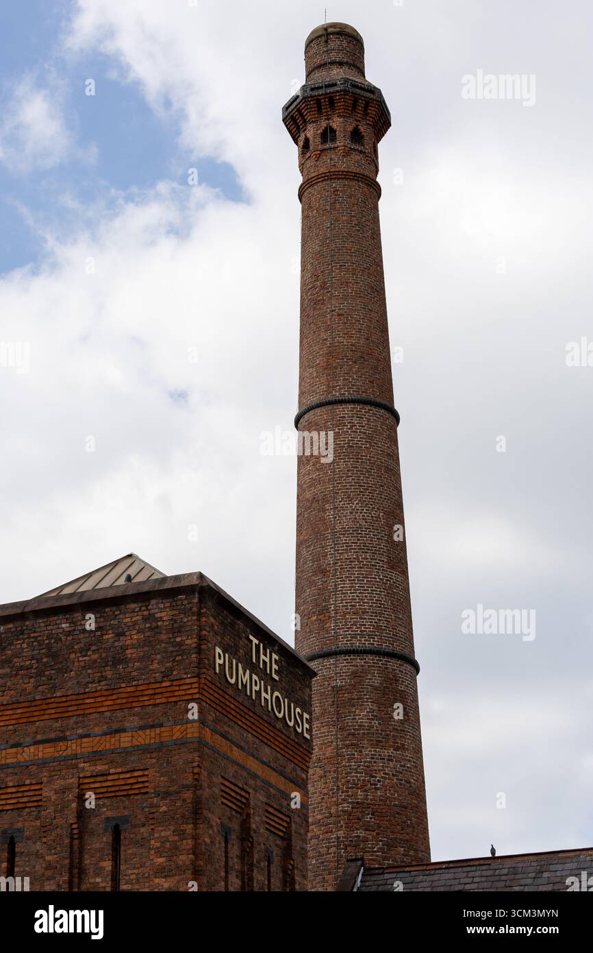 A tall, red brick industrial chimney stands beside a brick building ...