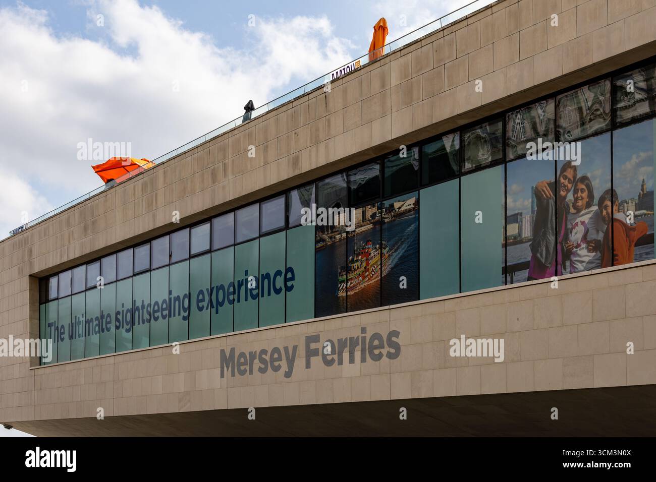 A modern building facade displays large windows with promotional ...