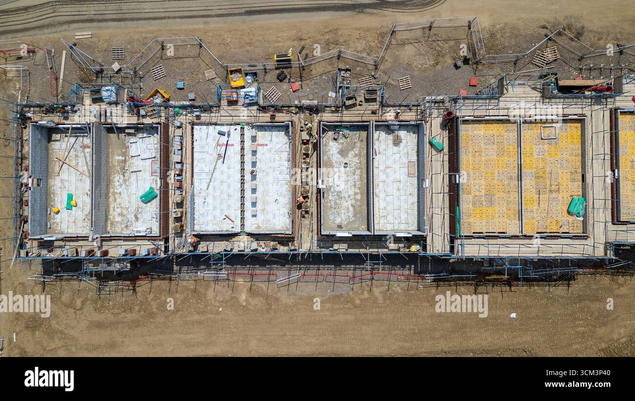 Aerial view of a construction site featuring a linear arrangement of ...