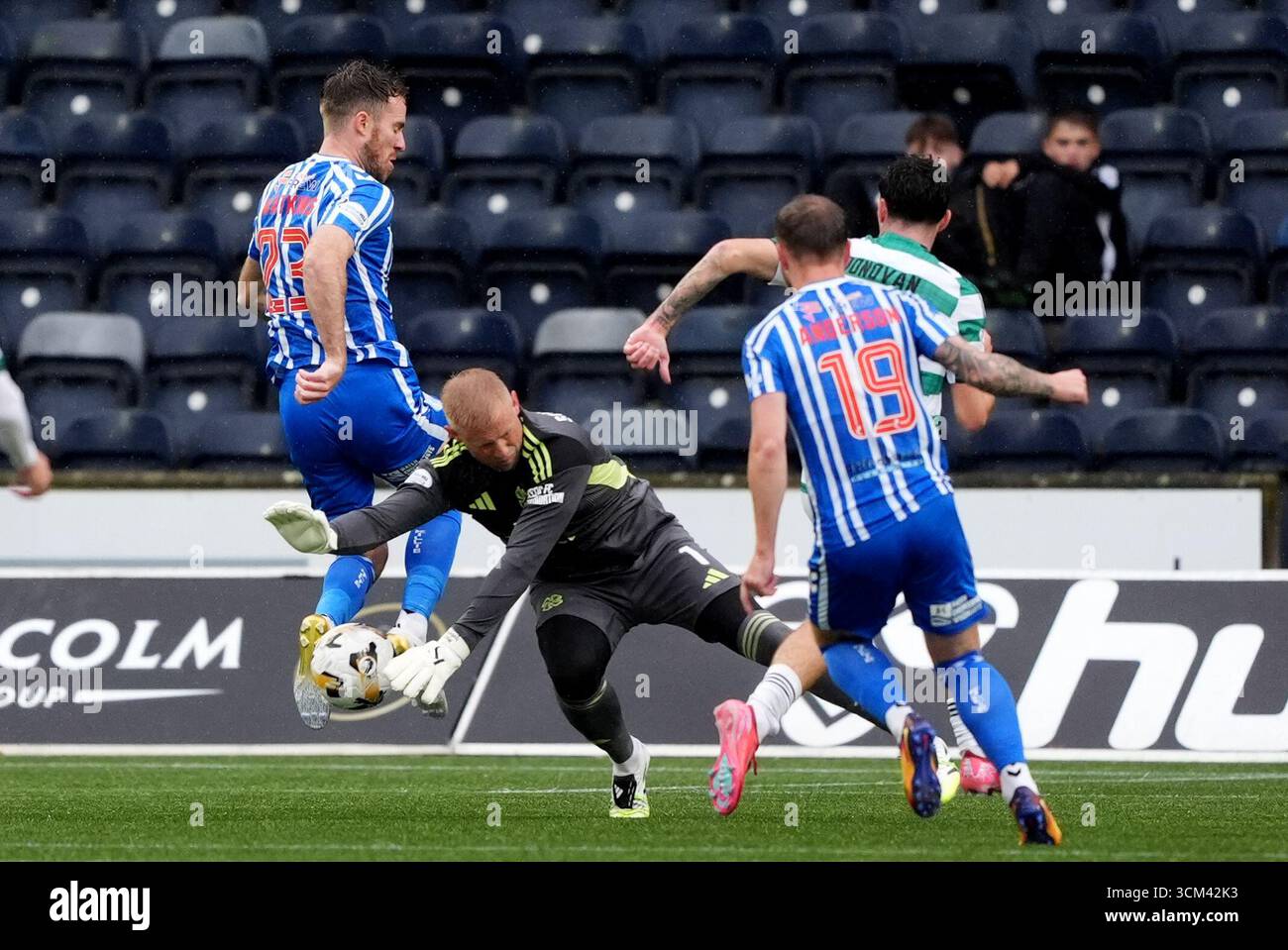 Celtic goalkeeper Kasper Schmeichel saves at the feet of Kilmarnock's ...