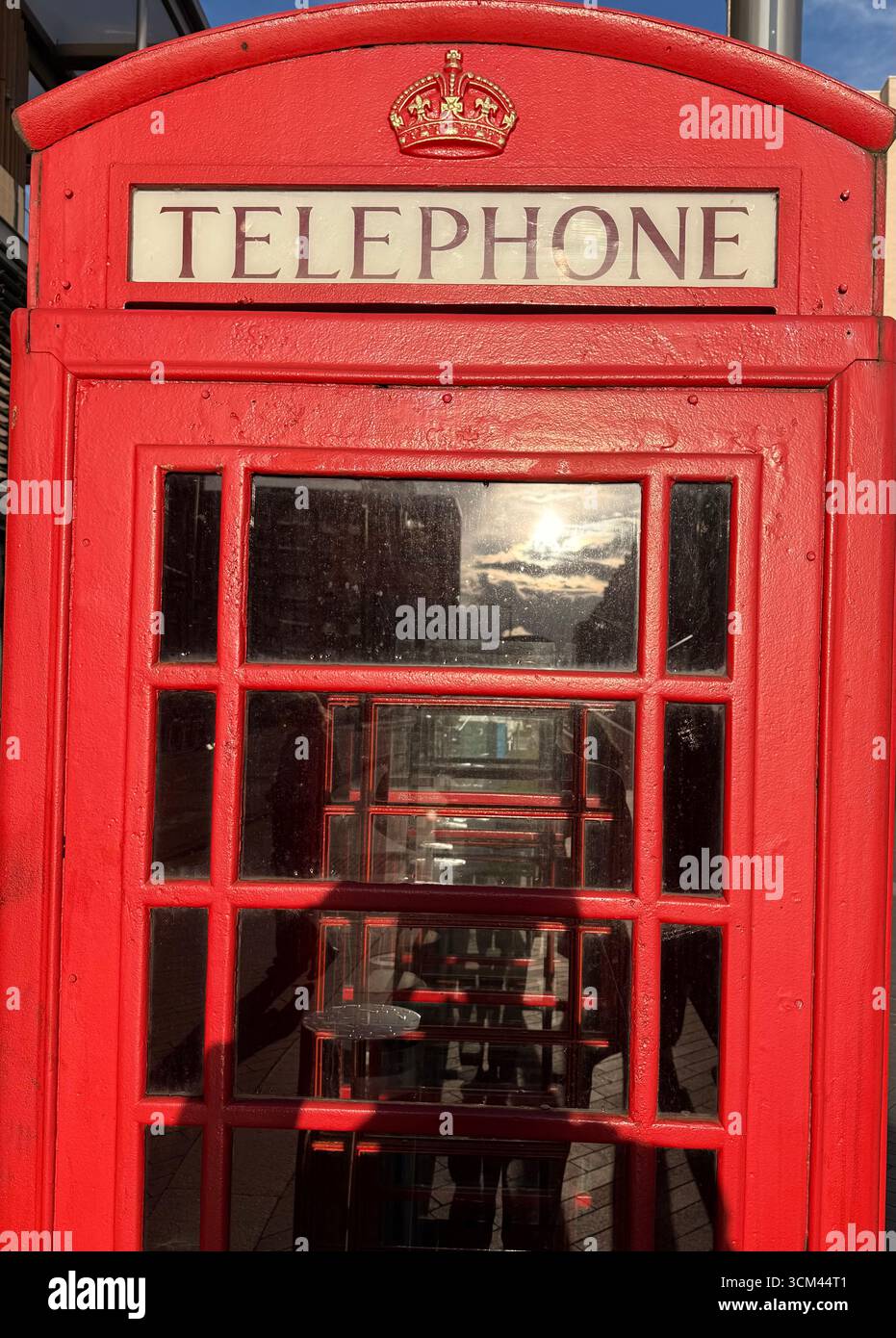 Red K2 telephone box with late evening sun reflecting in window ...