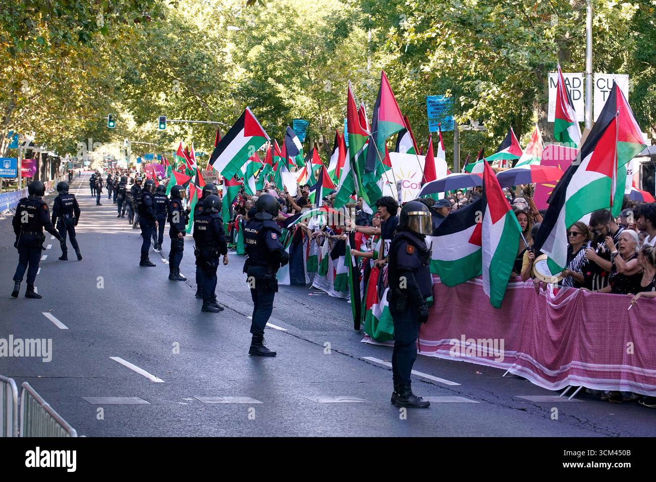 Police officers cordon off the area as people shout slogans and hold ...