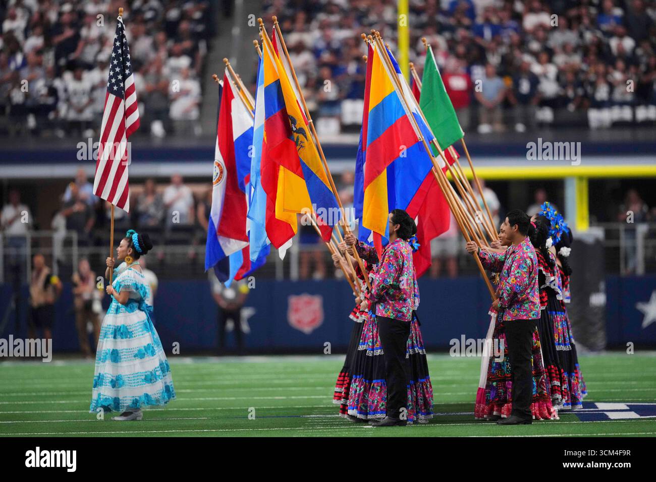 An American and several Latin American flags are held on the field ...