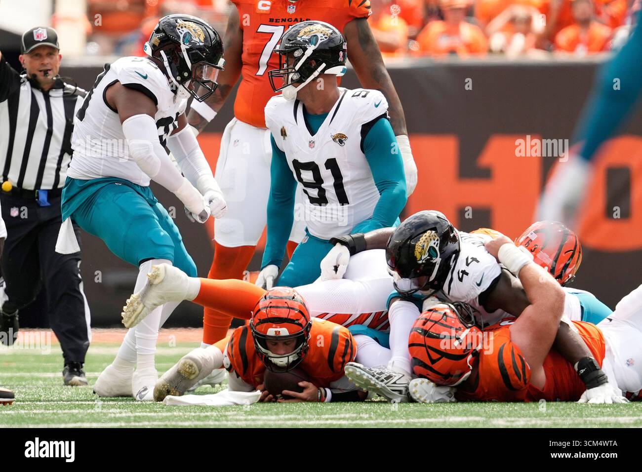 Cincinnati Bengals quarterback Joe Burrow, bottom left, is sacked by ...