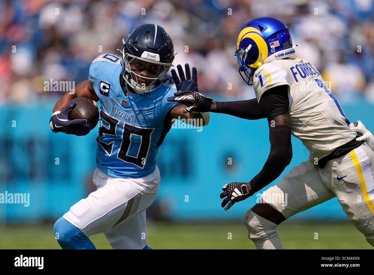 Tennessee Titans running back Tony Pollard, left, fends off Los Angeles ...