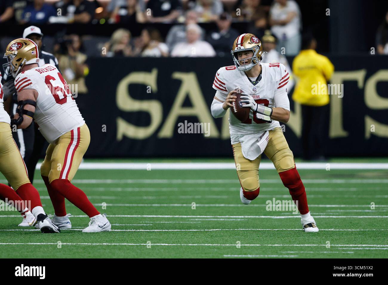 San Francisco 49ers quarterback Mac Jones rolls out to pass against the ...