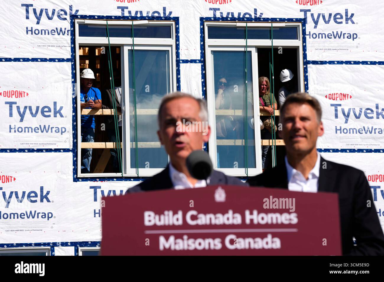 Workers from Caivan Homes look on from a modular home under ...