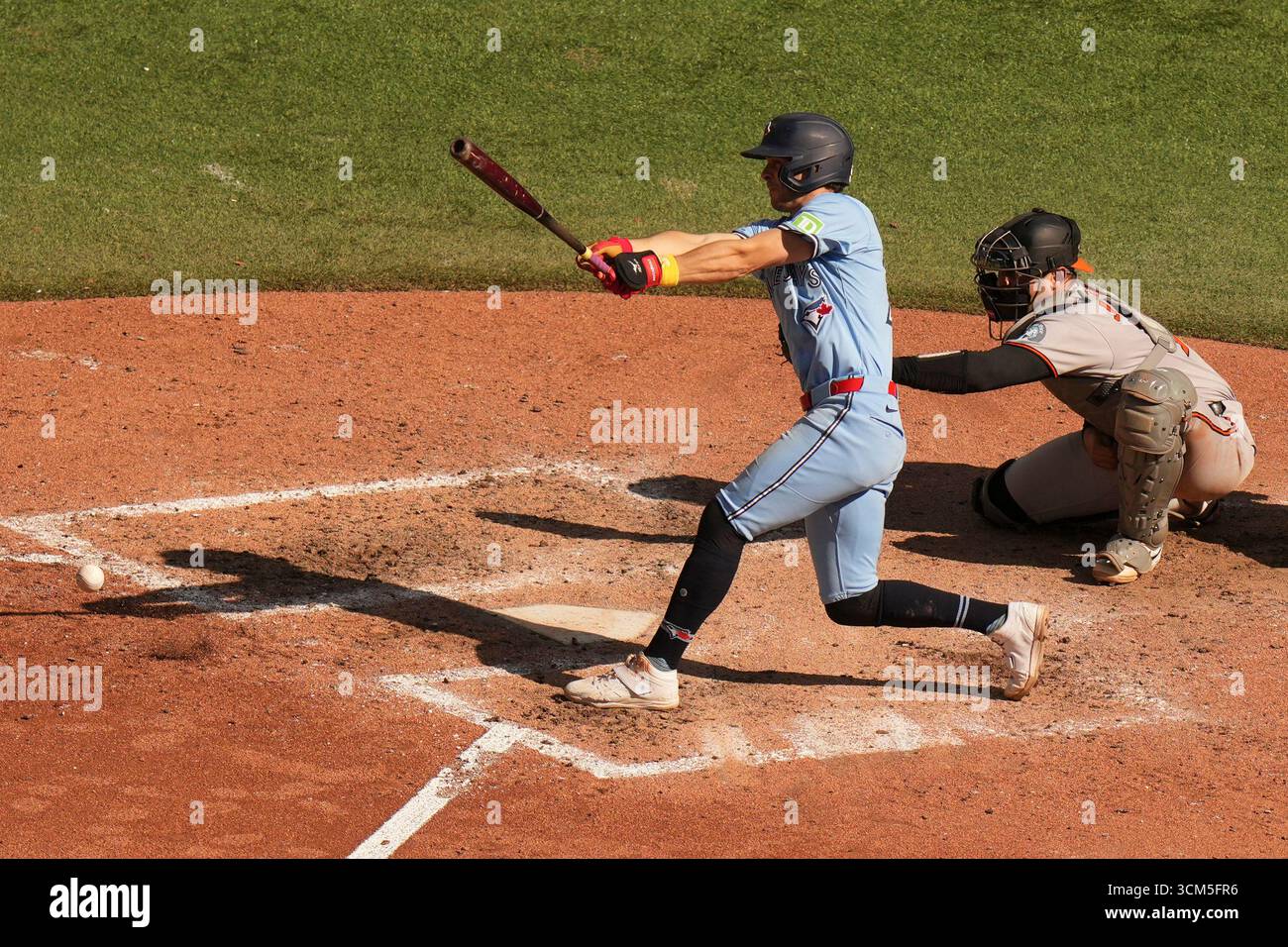 Toronto Blue Jays' Ernie Clement, left, hits an RBI single in front of ...