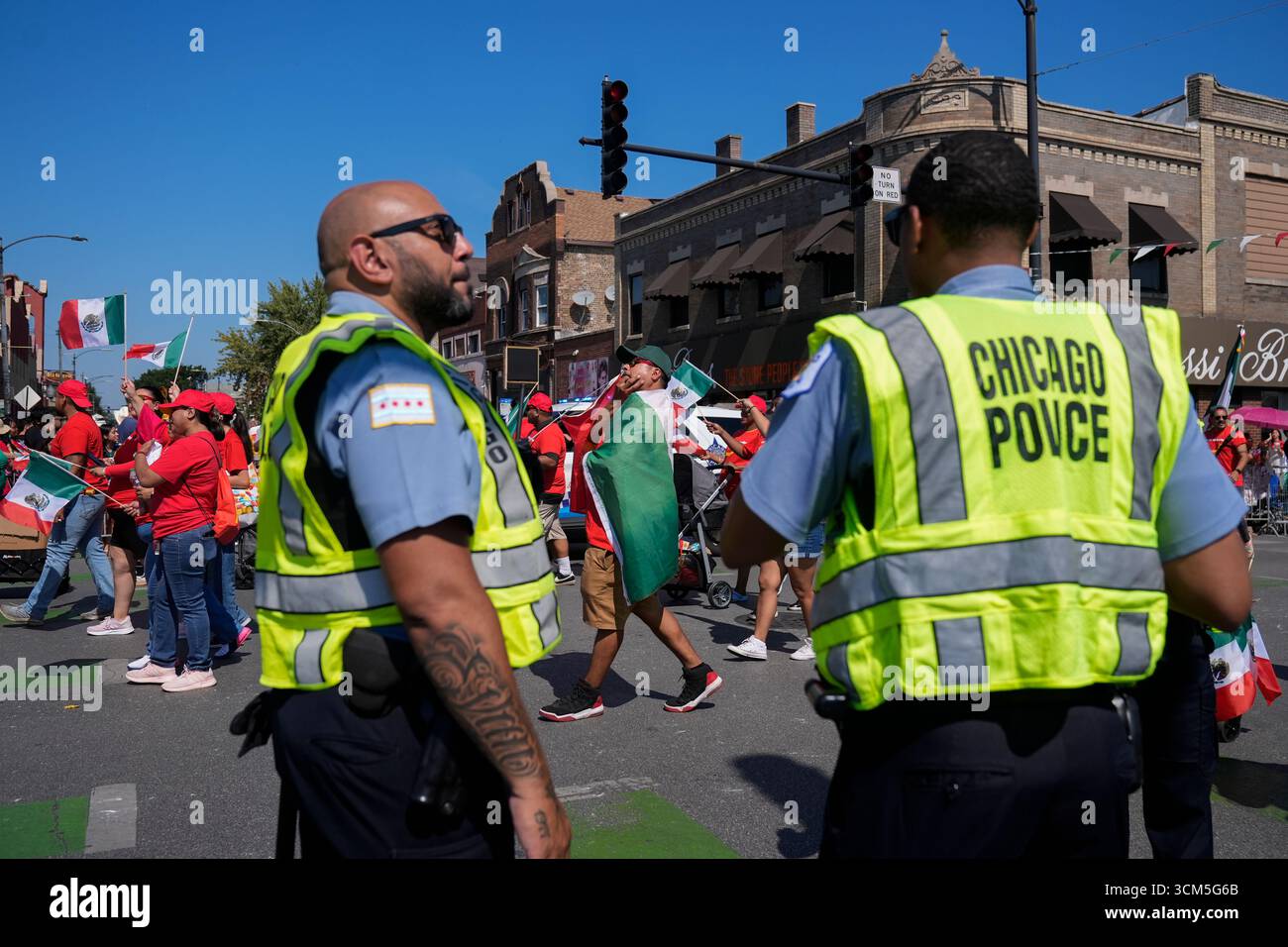 Police officers stand by as people march in the Mexican Independence ...