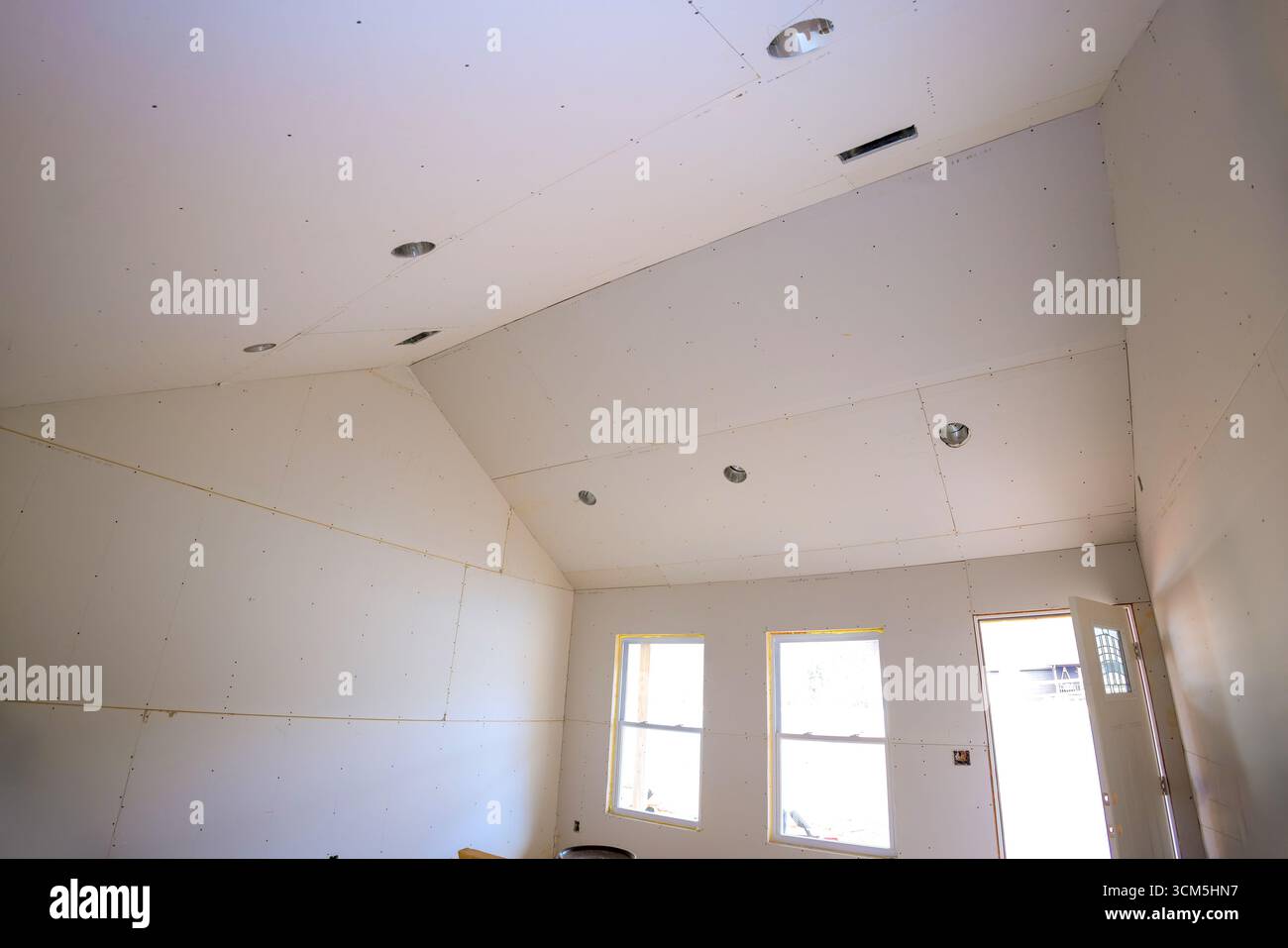 Unfinished interior space with drywall installation underway ...