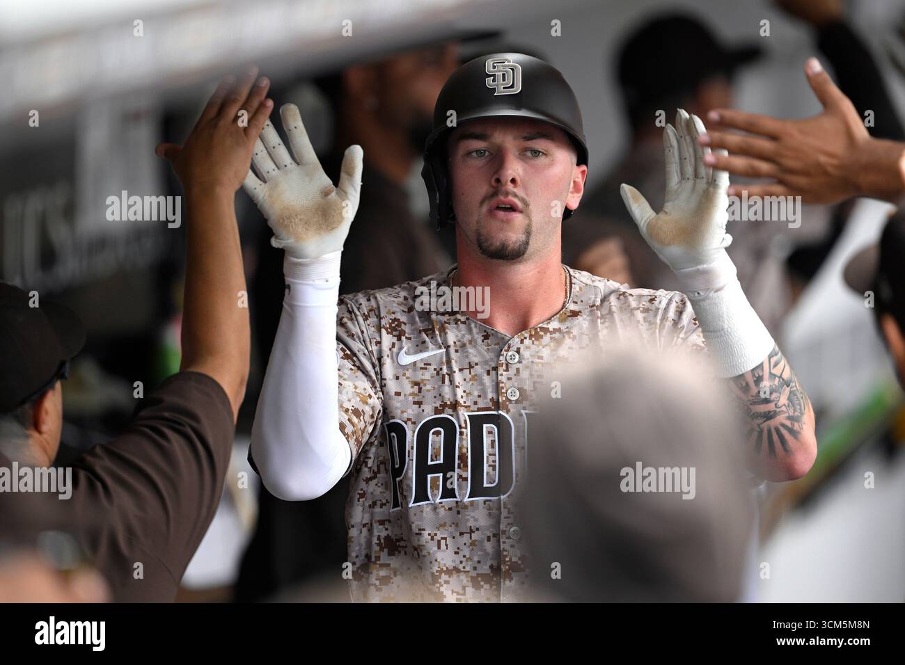 San Diego Padres' Jackson Merrill is congratulated in the dugout after ...