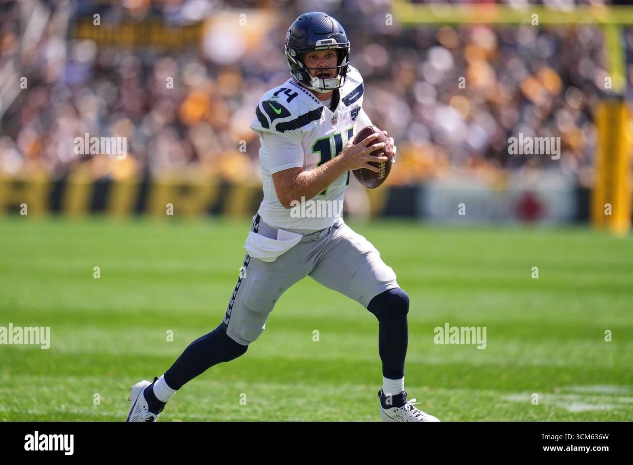 Seattle Seahawks quarterback Sam Darnold (14) rolls out looking to pass ...