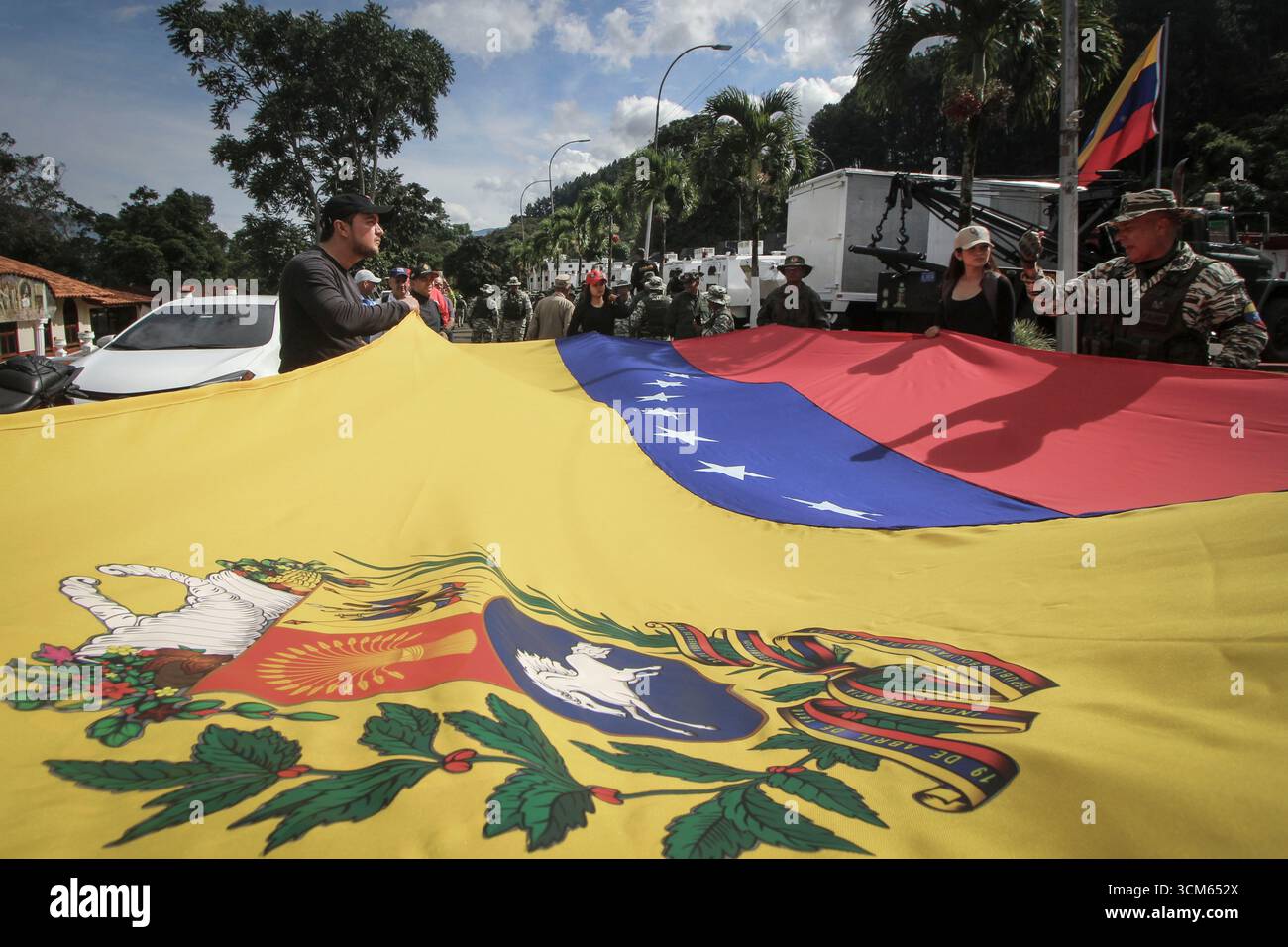 Several civilians and soldiers holding a flag perform formations during ...