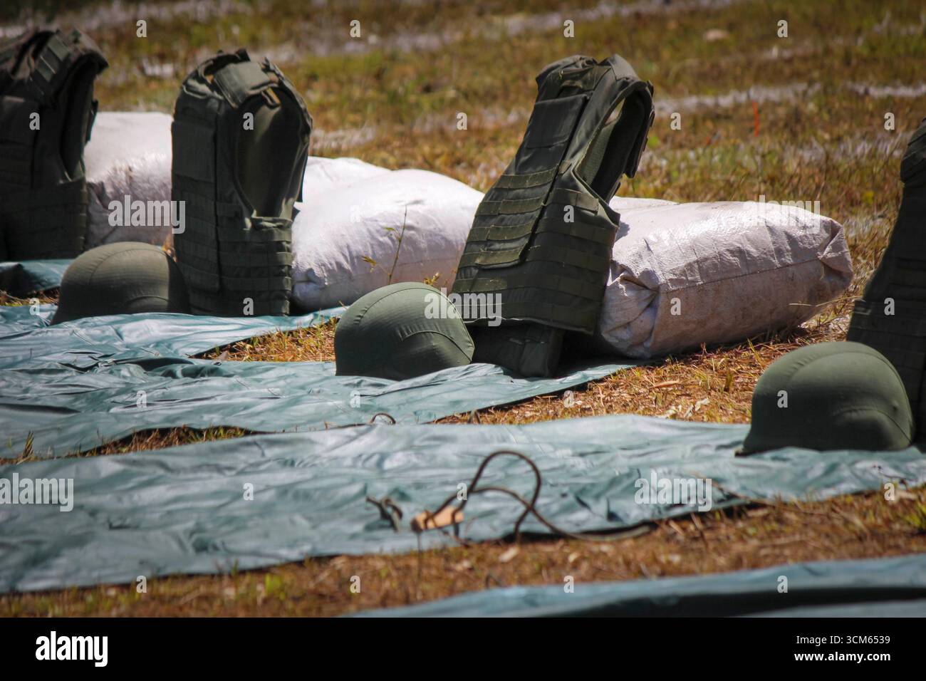 Several helmets and bulletproof vests lie on the ground at a shooting ...