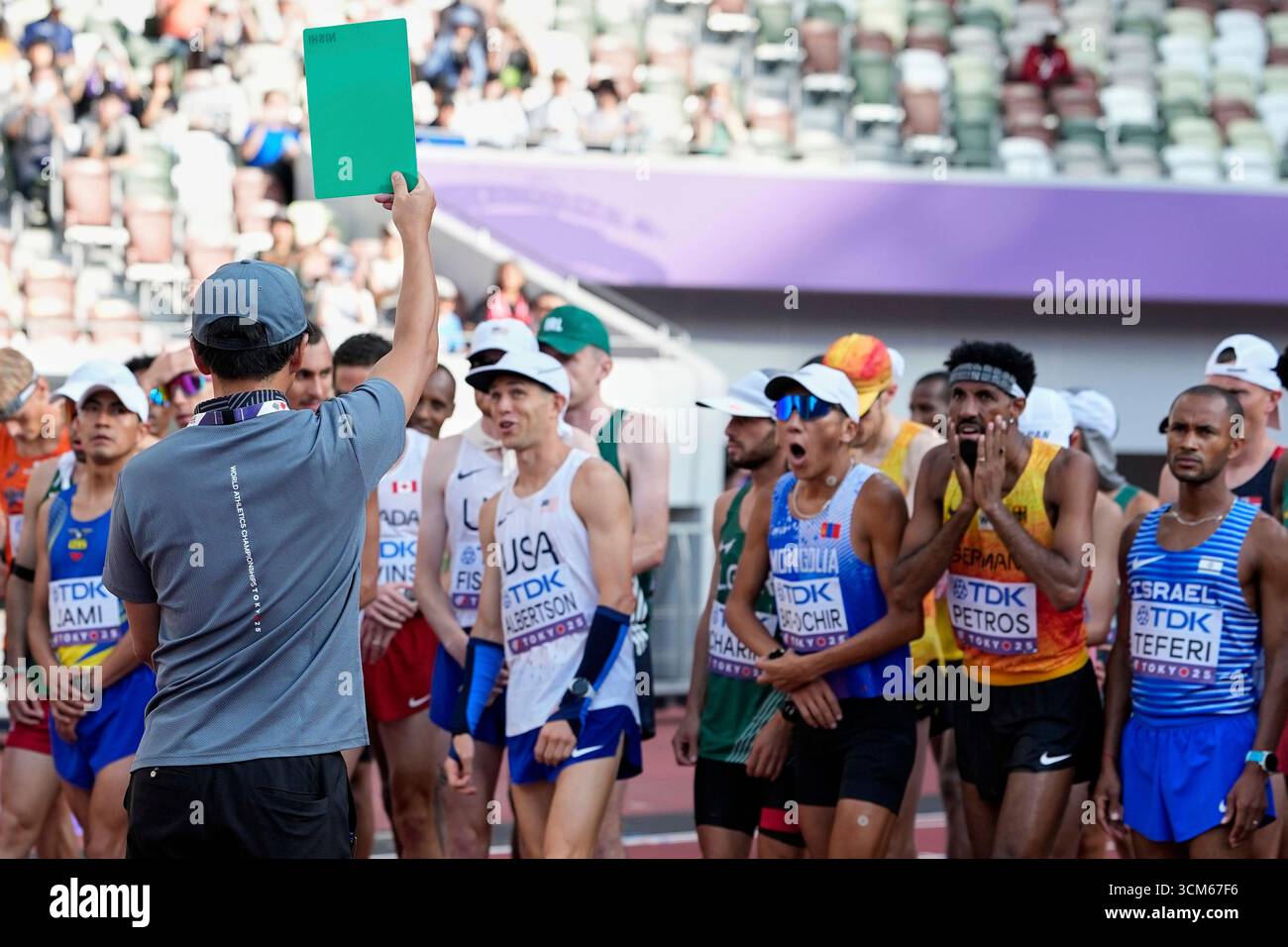 Runners react as an official shows a green card after a false start in ...