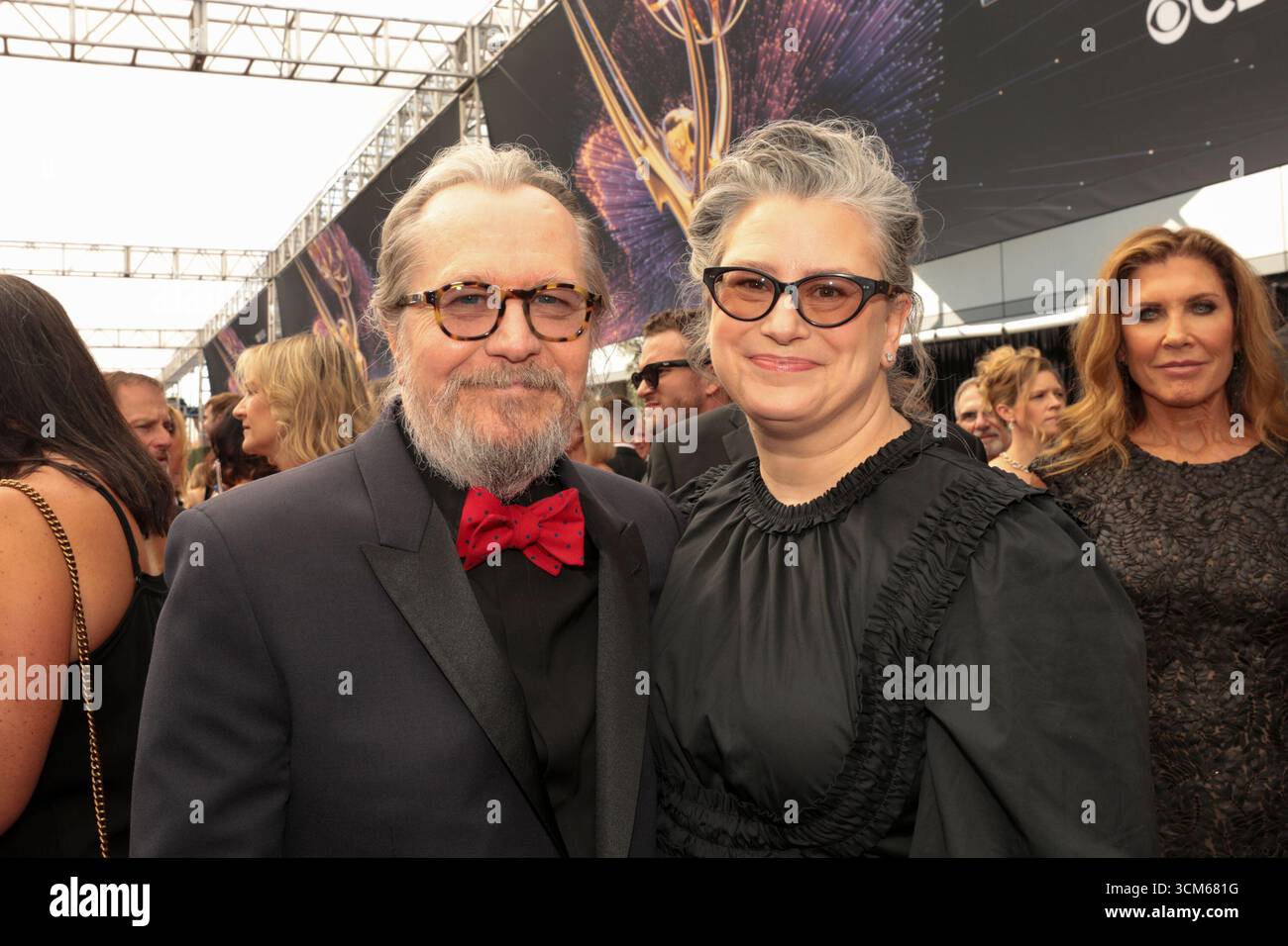 Gary Oldman, left, and Gisele Schmidt walk the red carpet at the 77th ...
