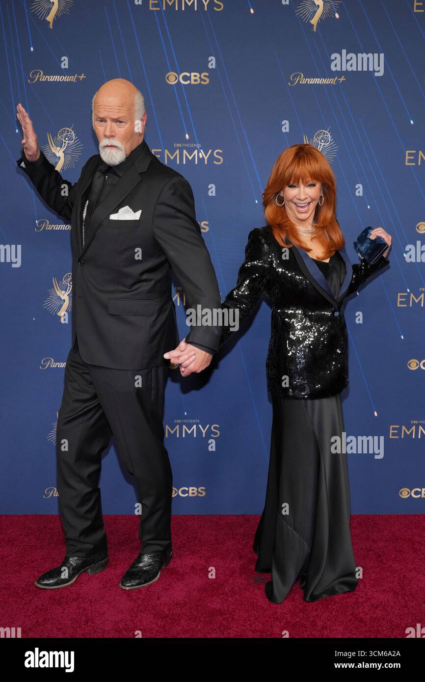 Rex Linn, left, and Reba McEntire arrive at the 77th Emmy Awards on Sunday, Sept. 14, 2025 at ...
