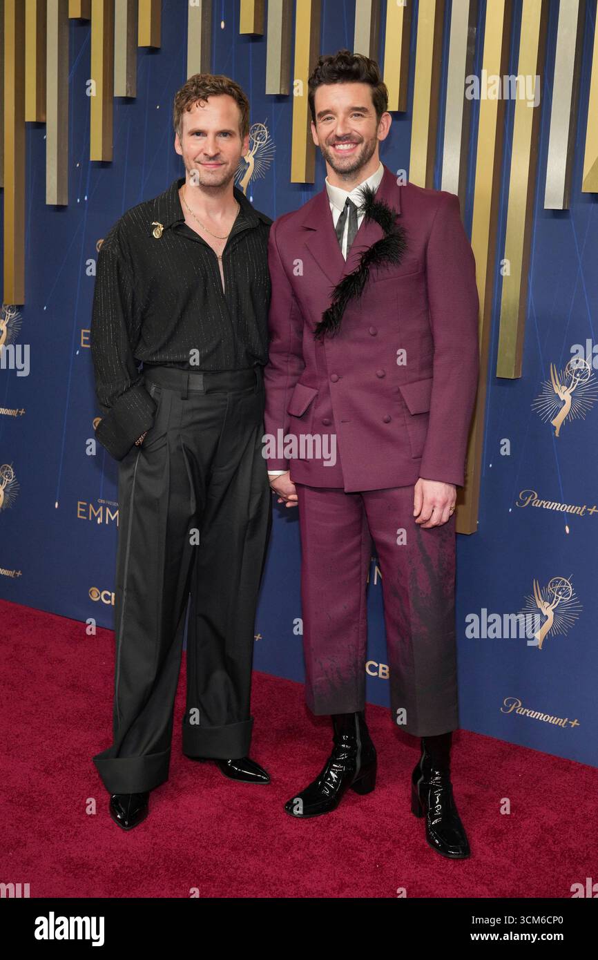 Ryan Spahn, left, and Michael Urie arrive at the 77th Emmy Awards on ...