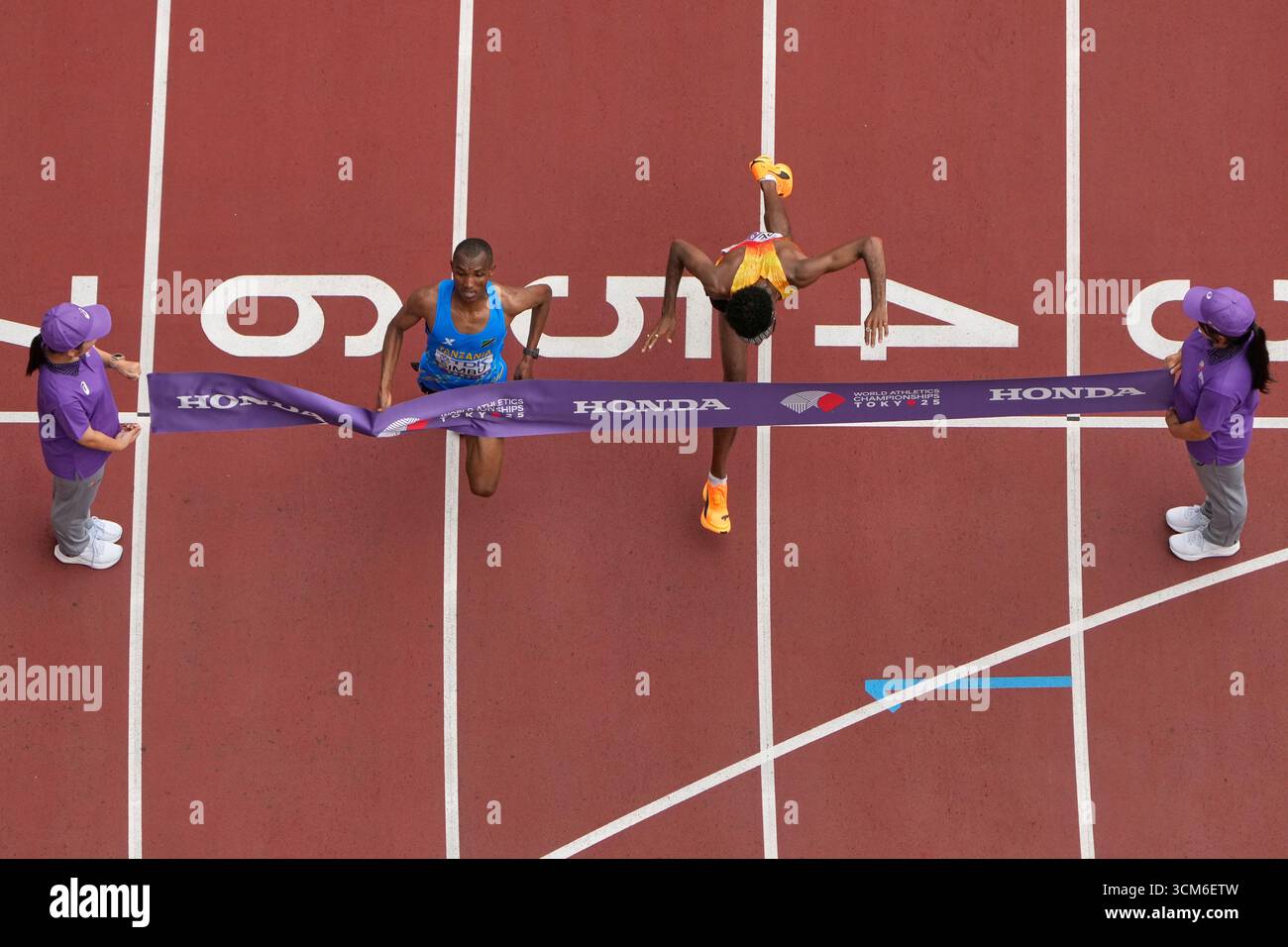 Tanzania's Alphonce Felix Simbu, left, crosses the finish line ahead of ...