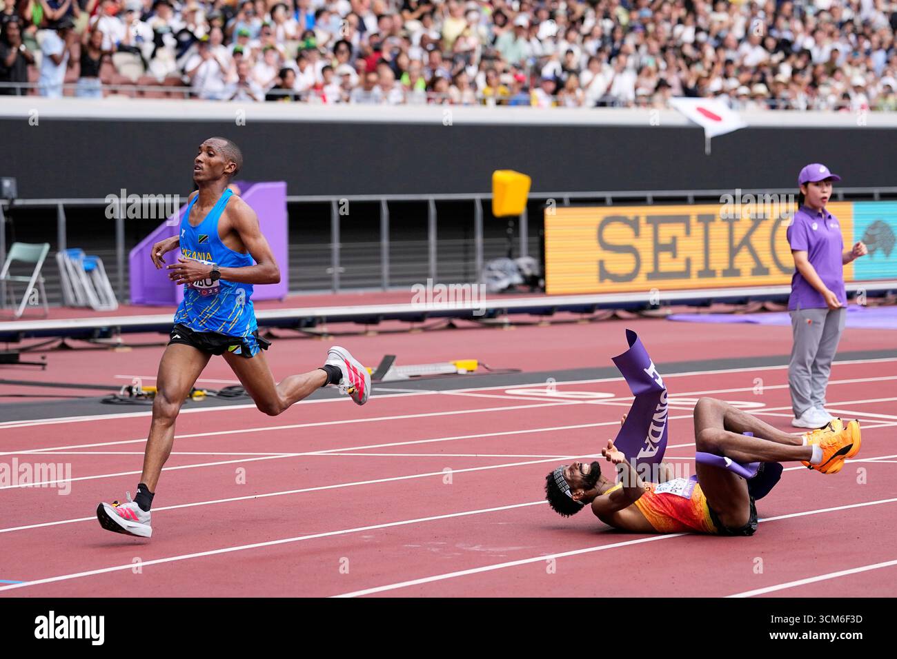 Tanzania's Alphonce Felix Simbu, left, crosses the finish line to win ...