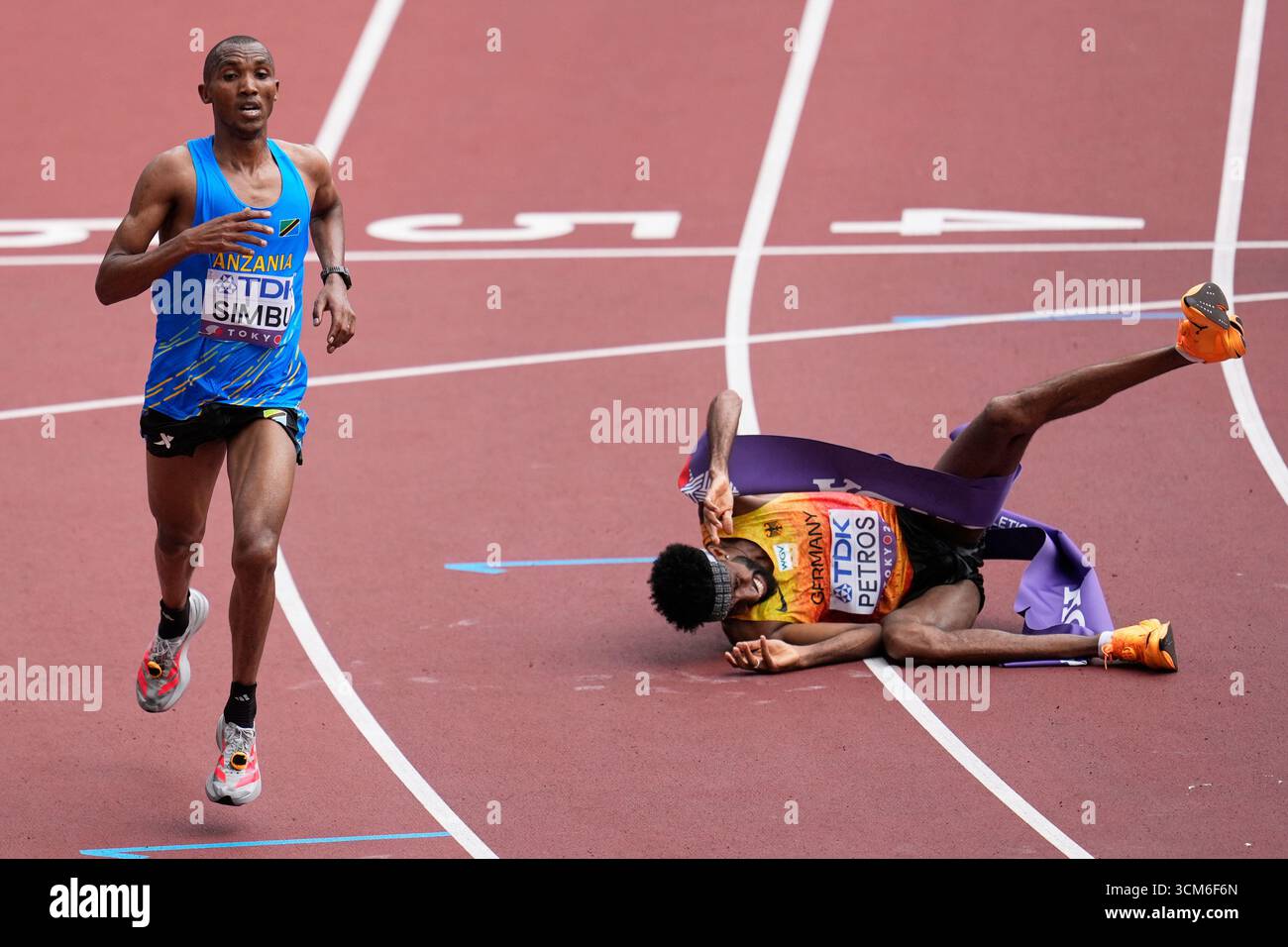 Germany's Amanal Petros, right, falls as he and Tanzania's Alphonce ...