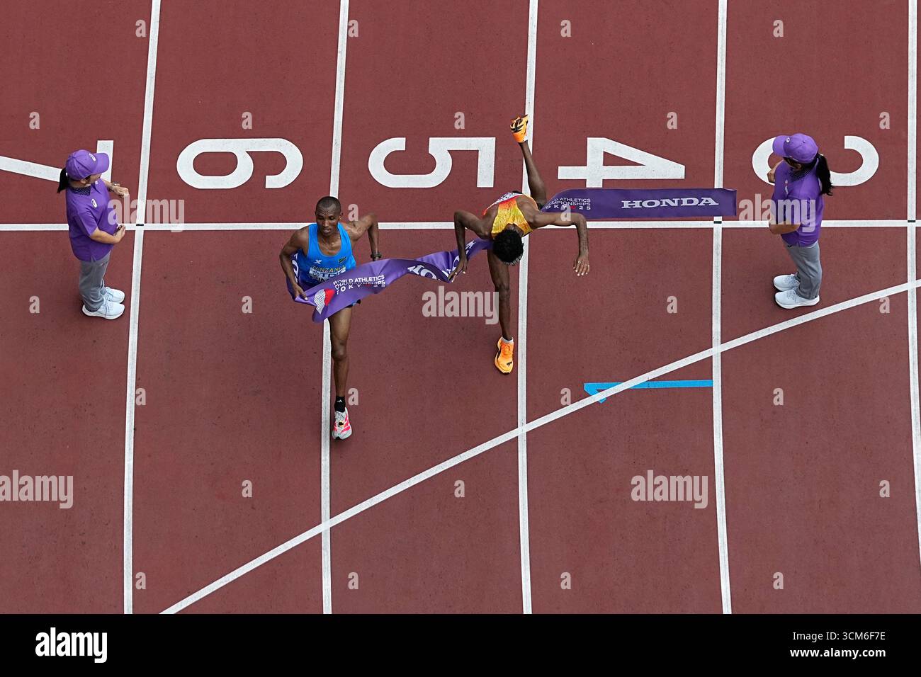 Tanzania's Alphonce Felix Simbu, left, crosses the finish line ahead of ...