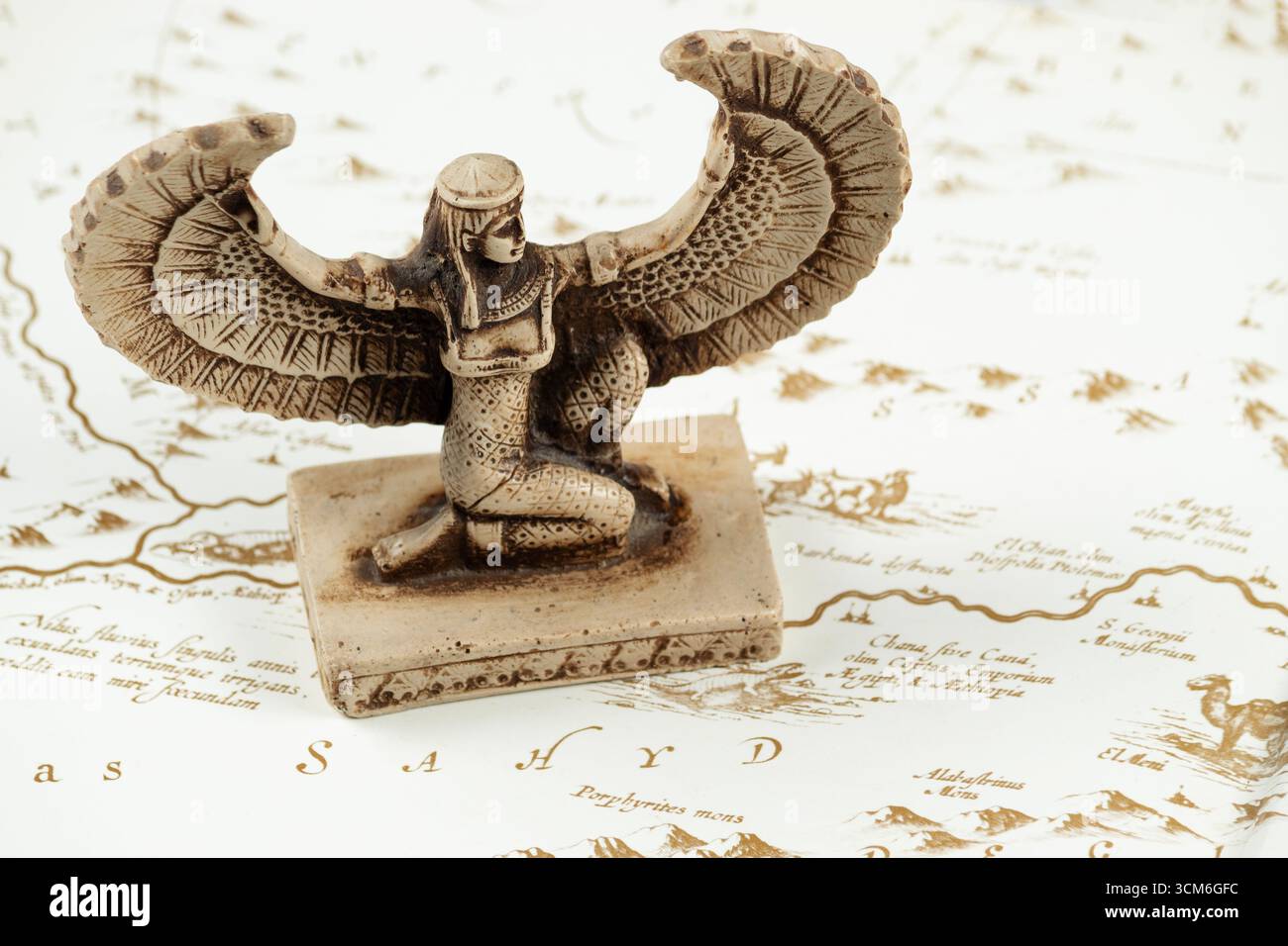 Close up to an Isis goddess small sculpturte over an antique egypt map ...