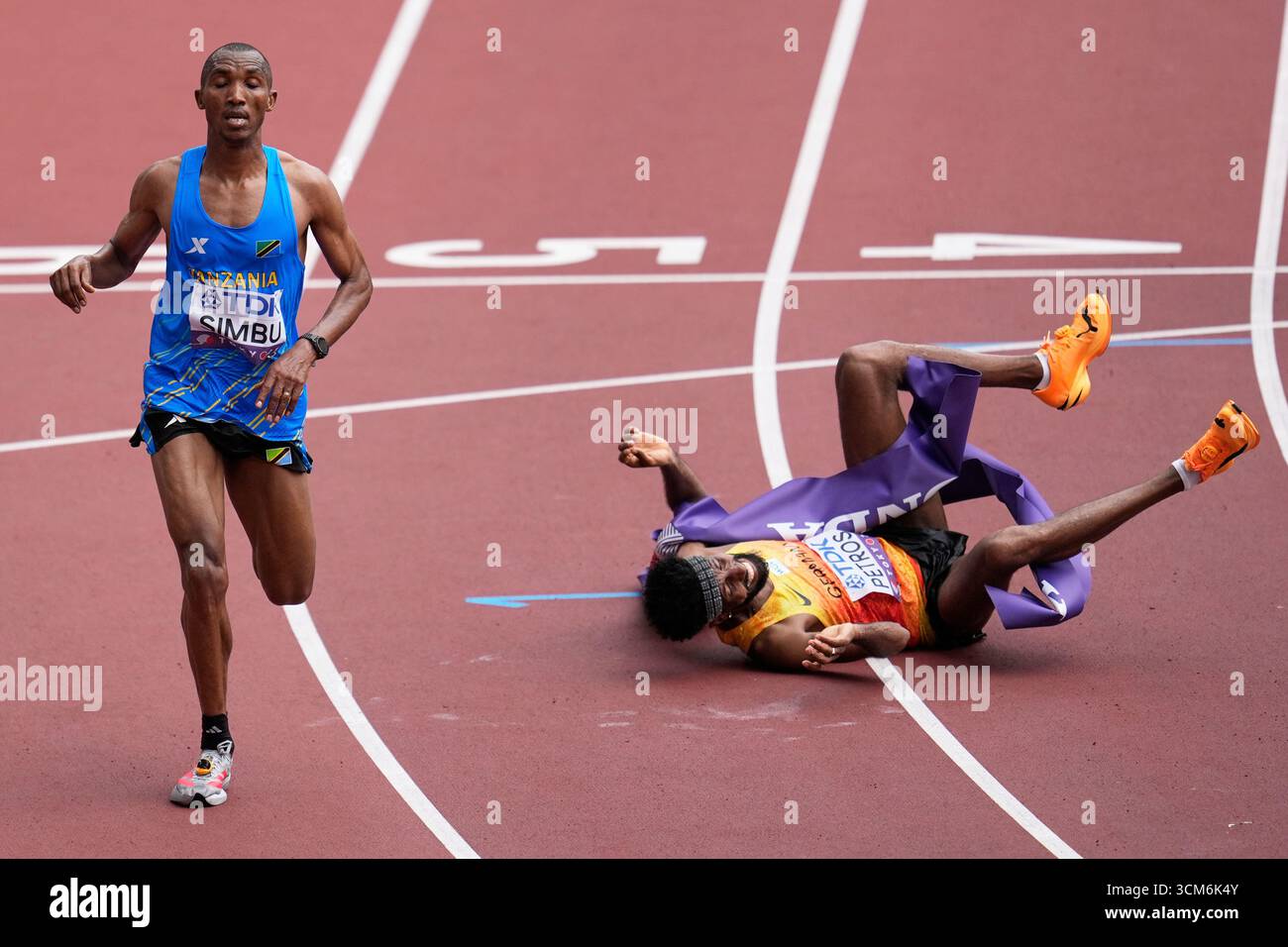 Germany's Amanal Petros, right, falls as he and Tanzania's Alphonce ...