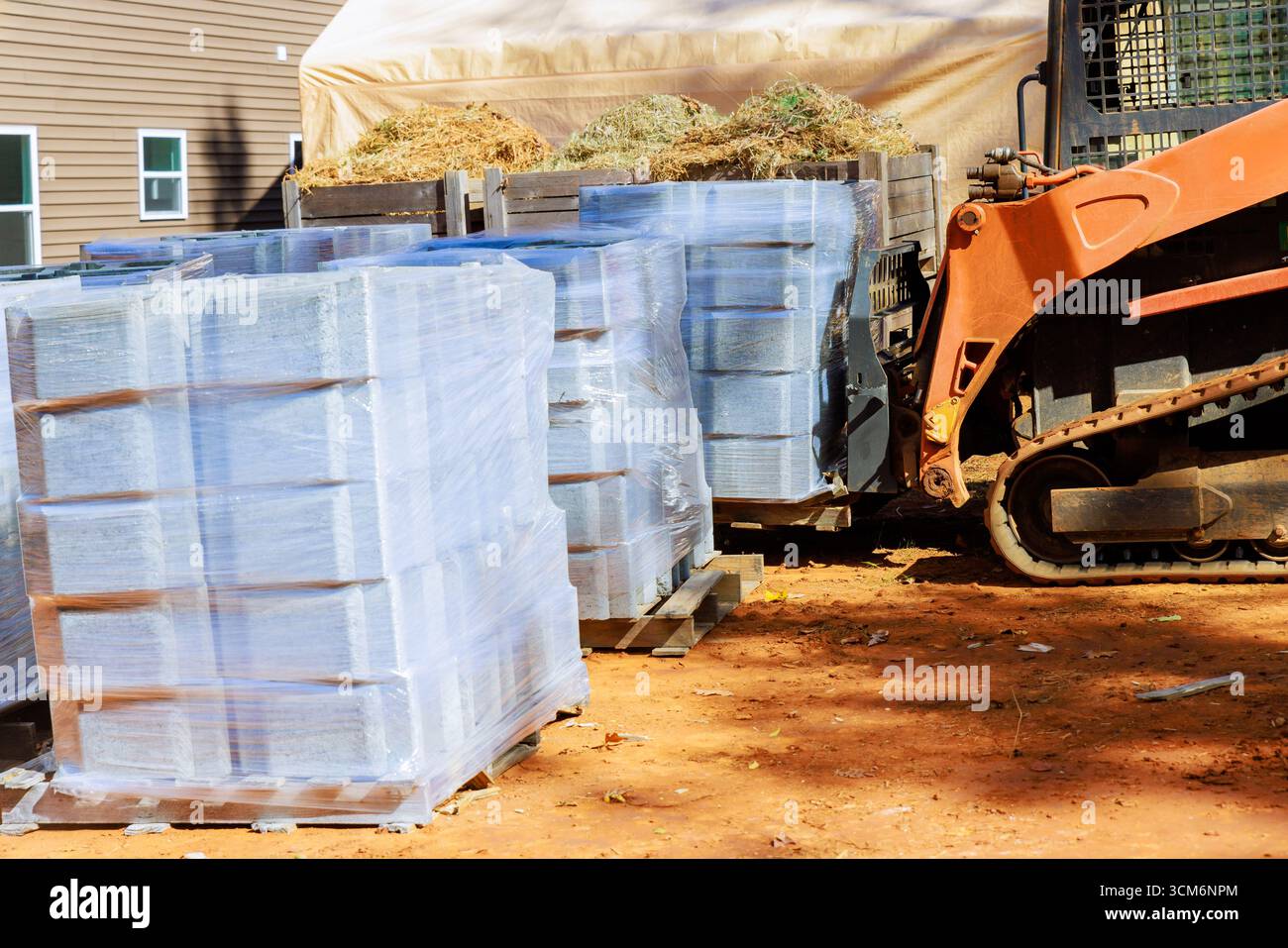 Heavy machinery is cement block unloading wrapped construction ...