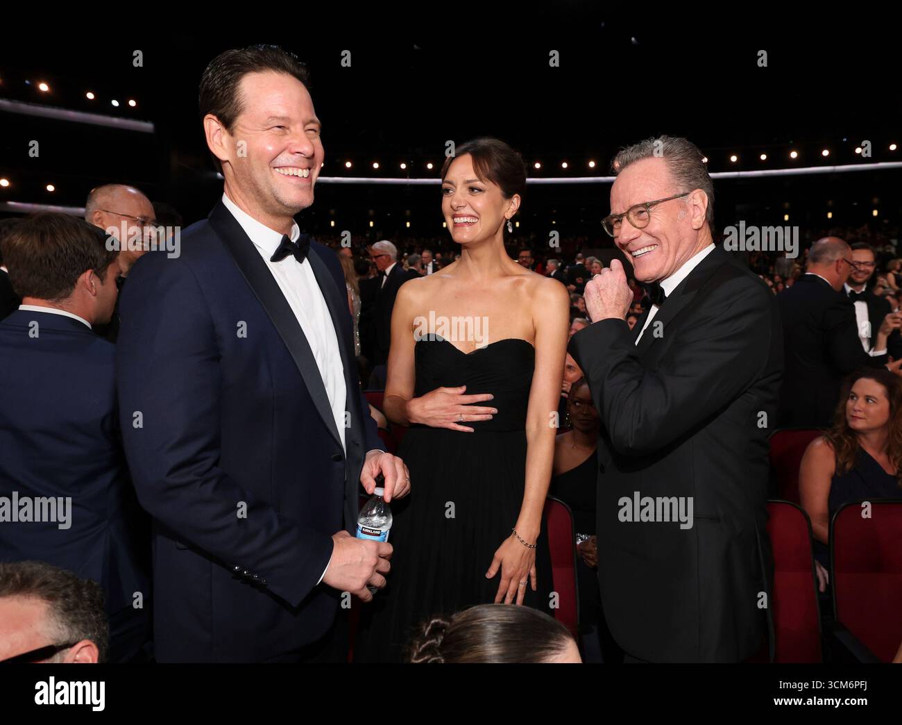 Ike Barinholtz, left, Erica Hanson and Bryan Cranston at the 77th Emmy ...