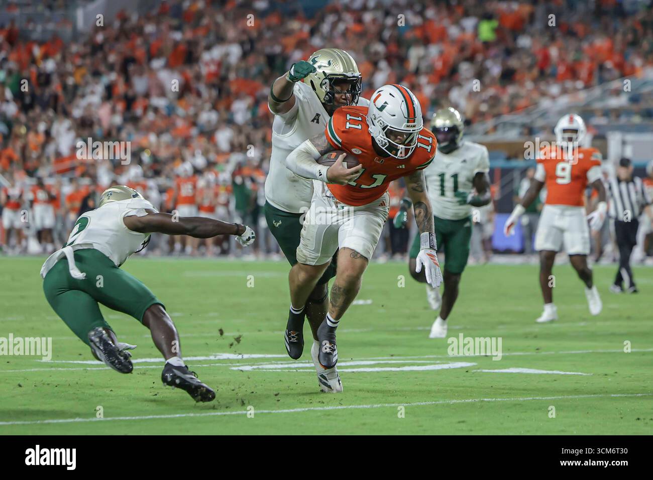 Miami, FL: Miami Hurricanes quarterback Carson Beck (11) runs the ball ...