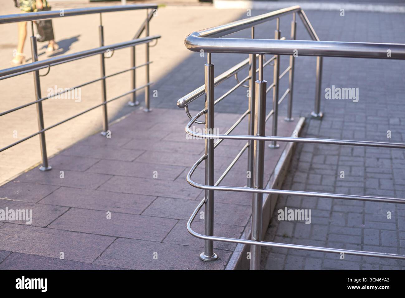 Modern metal railings and ramp in urban setting with stone and concrete ...